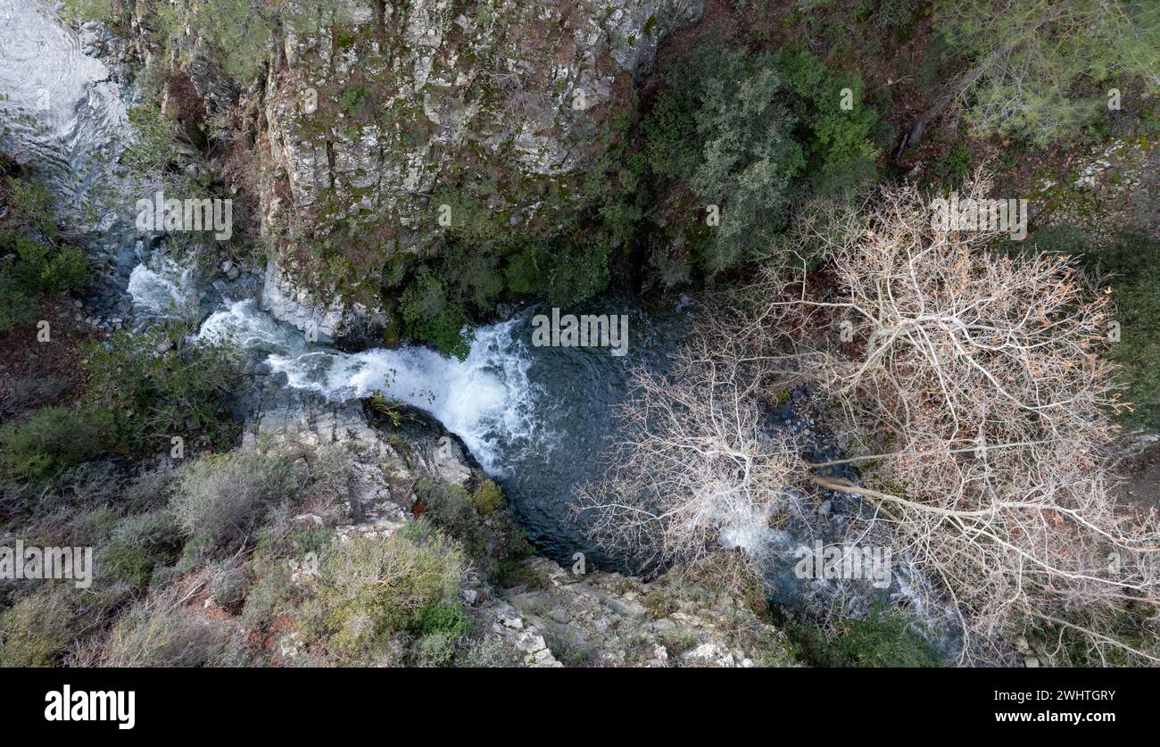 Drone aerial of waterfall flowing from a rocky cliff in the gorge ...