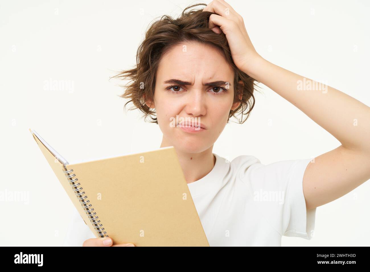 Portrait of confused girl scratching her head, holding planner, student ...