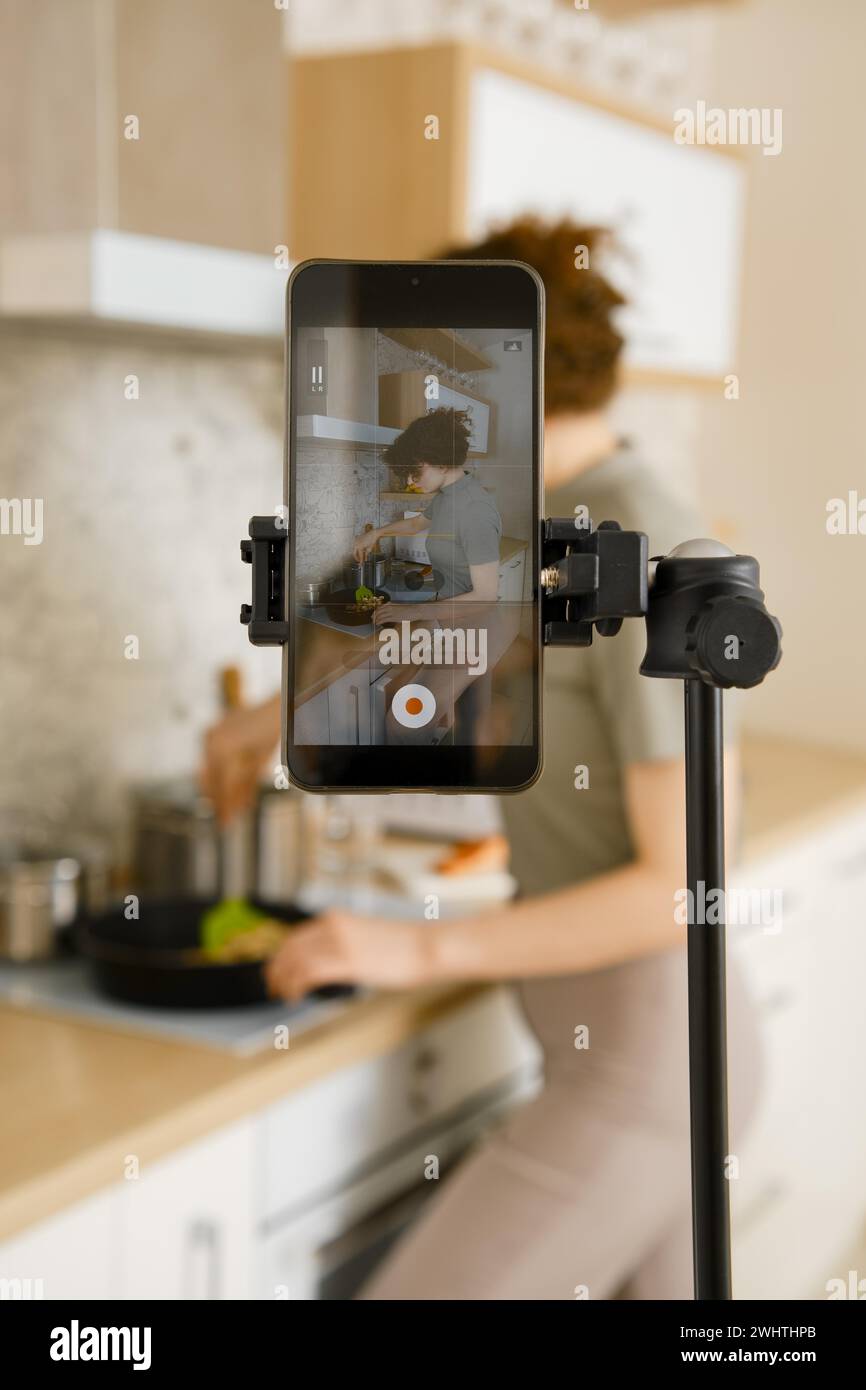 Food vlogger recording video in her kitchen, making step by step ...