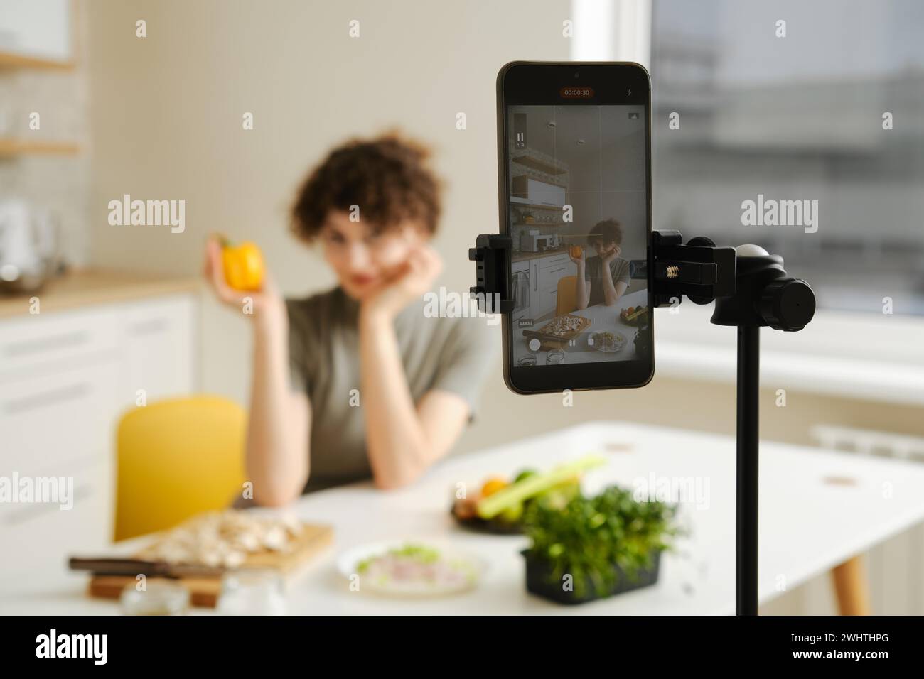 Cute woman recording on a smartphone her vlog about healthy eating and ...