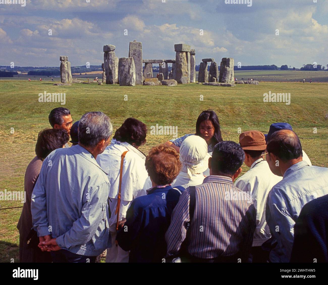 Group of Japanese tourists with guide visiting Stonehenge monument at ...