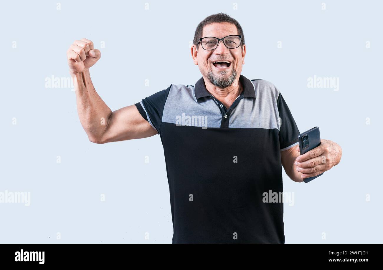 Happy winner senior man holding cell phone isolated. Senior person ...