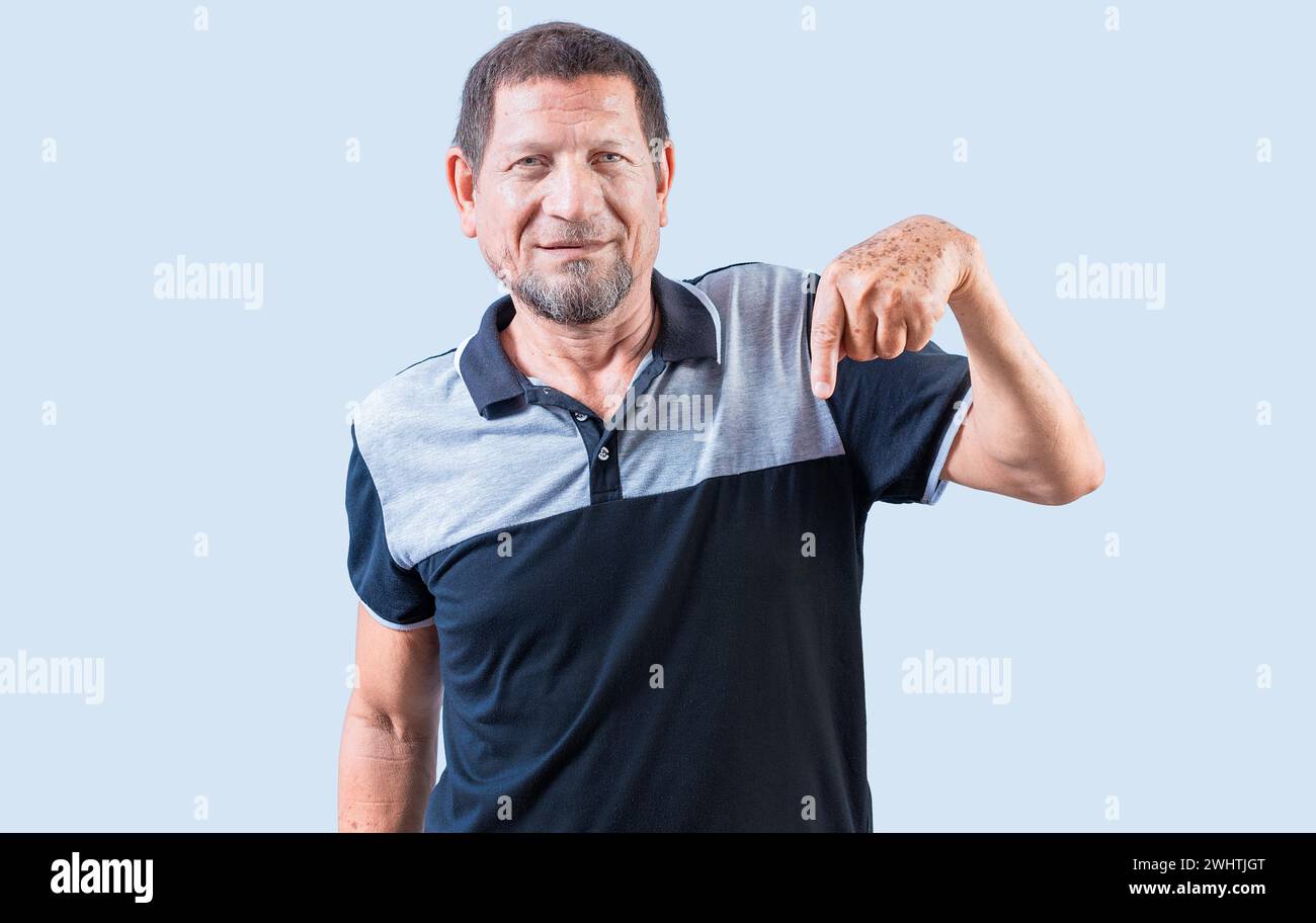 Senior old man pointing an advertisement down isolated. Smiling senior ...