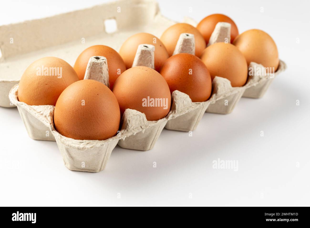 A tray of brown fresh hens eggs on white background. Eco-friendly egg ...