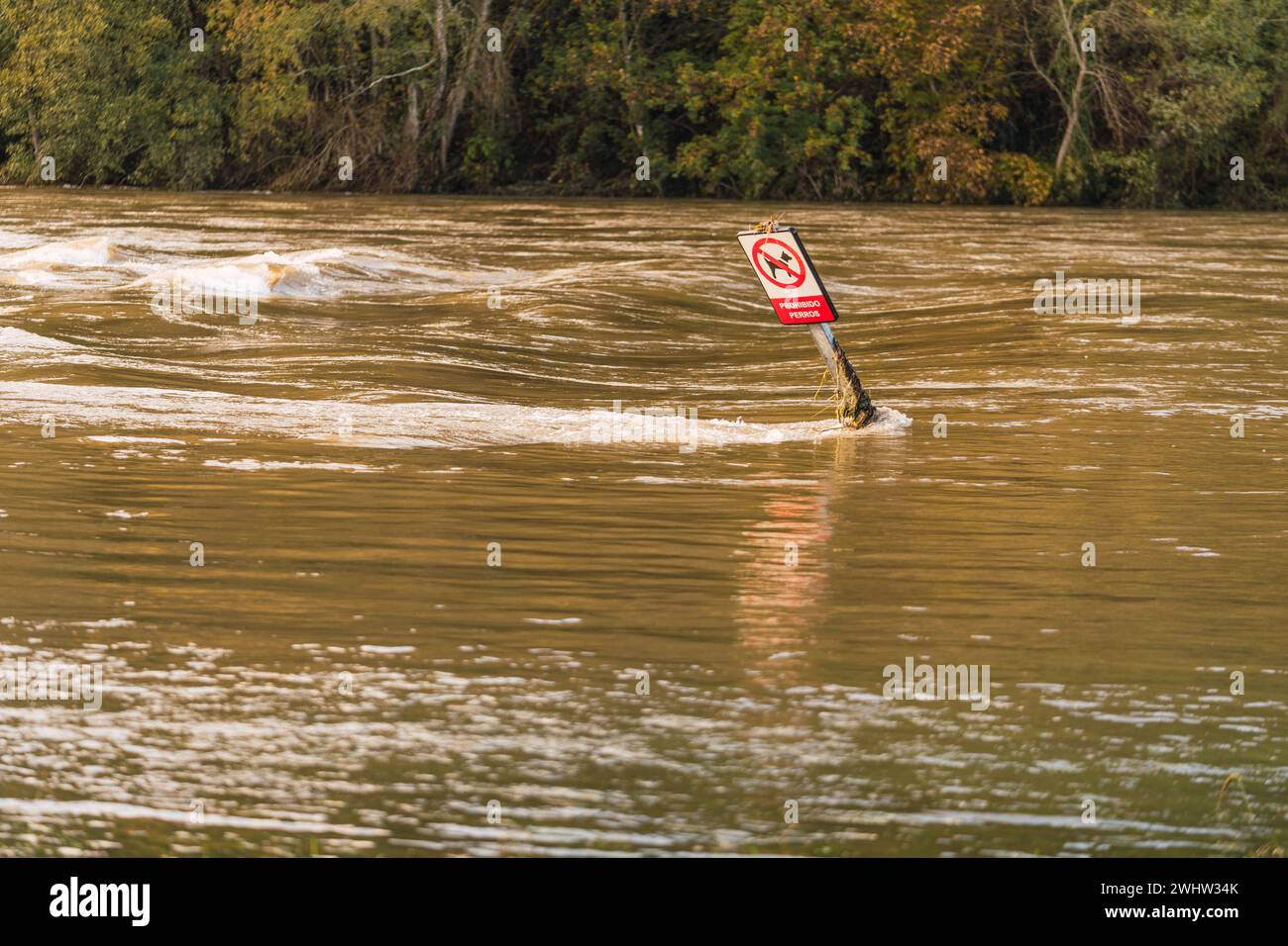 Road sign and sidewalk flooded due to river overflow due to constant ...