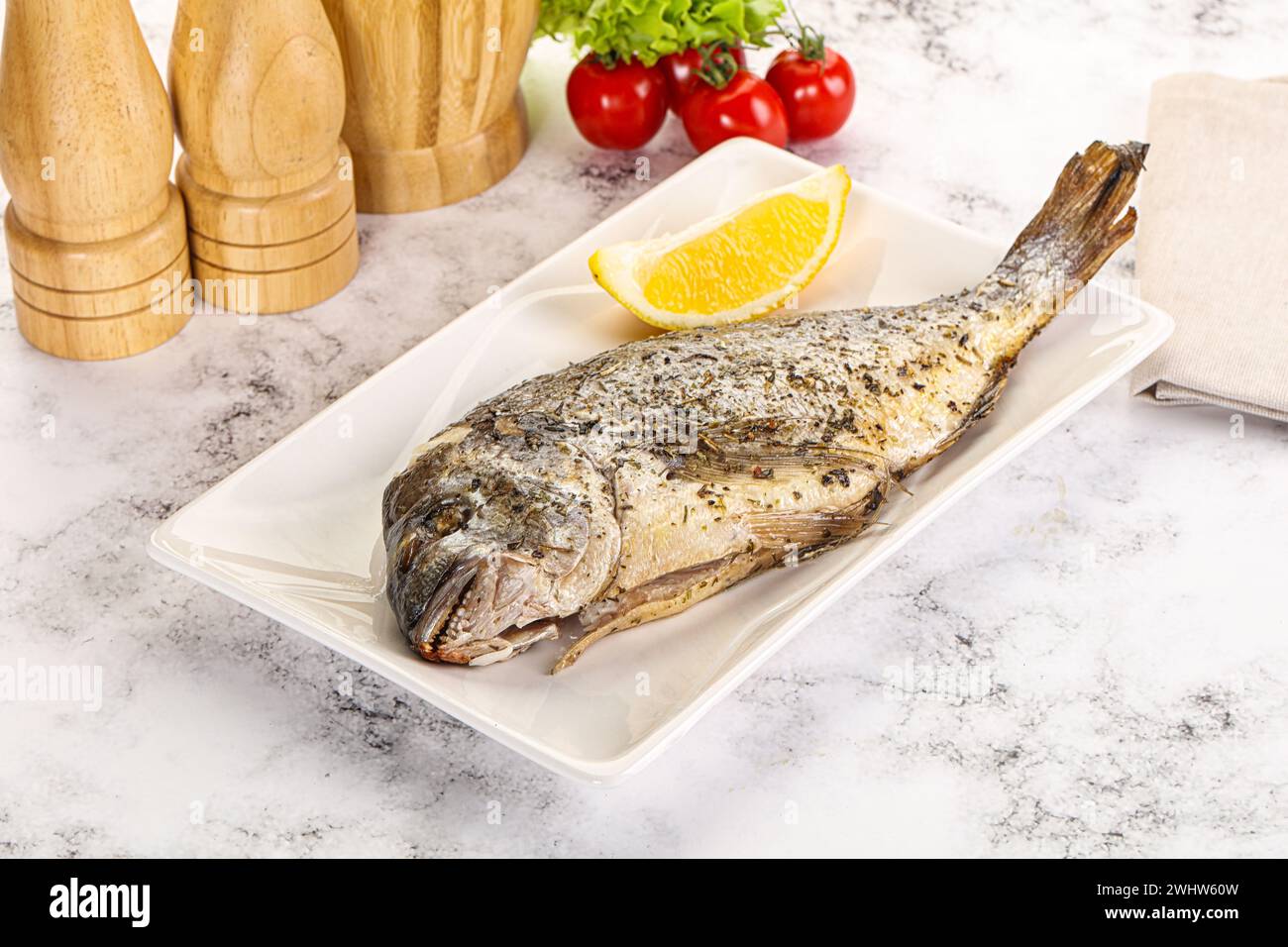 Baked Dorado fish served lemon slice Stock Photo - Alamy