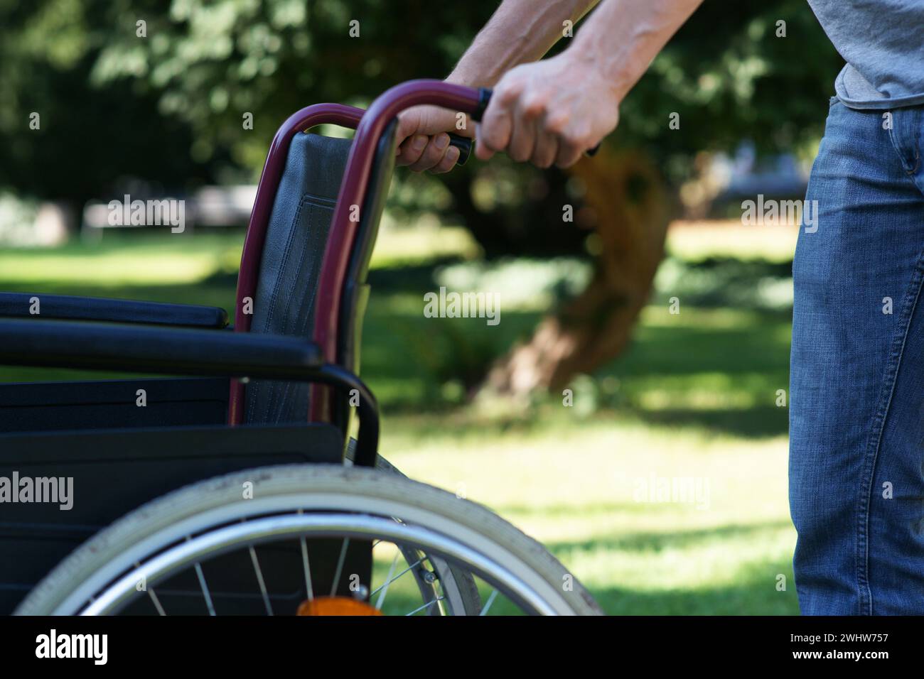 First steps on his own - man pushes empty wheel chair Stock Photo - Alamy