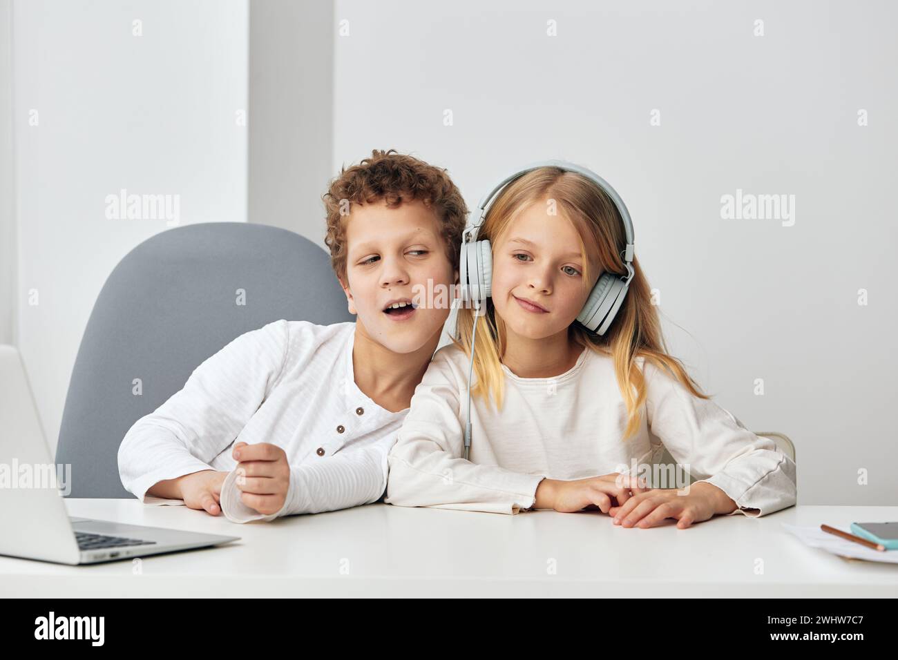 Happy boy and girl sitting at home in the living room, engrossed in ...