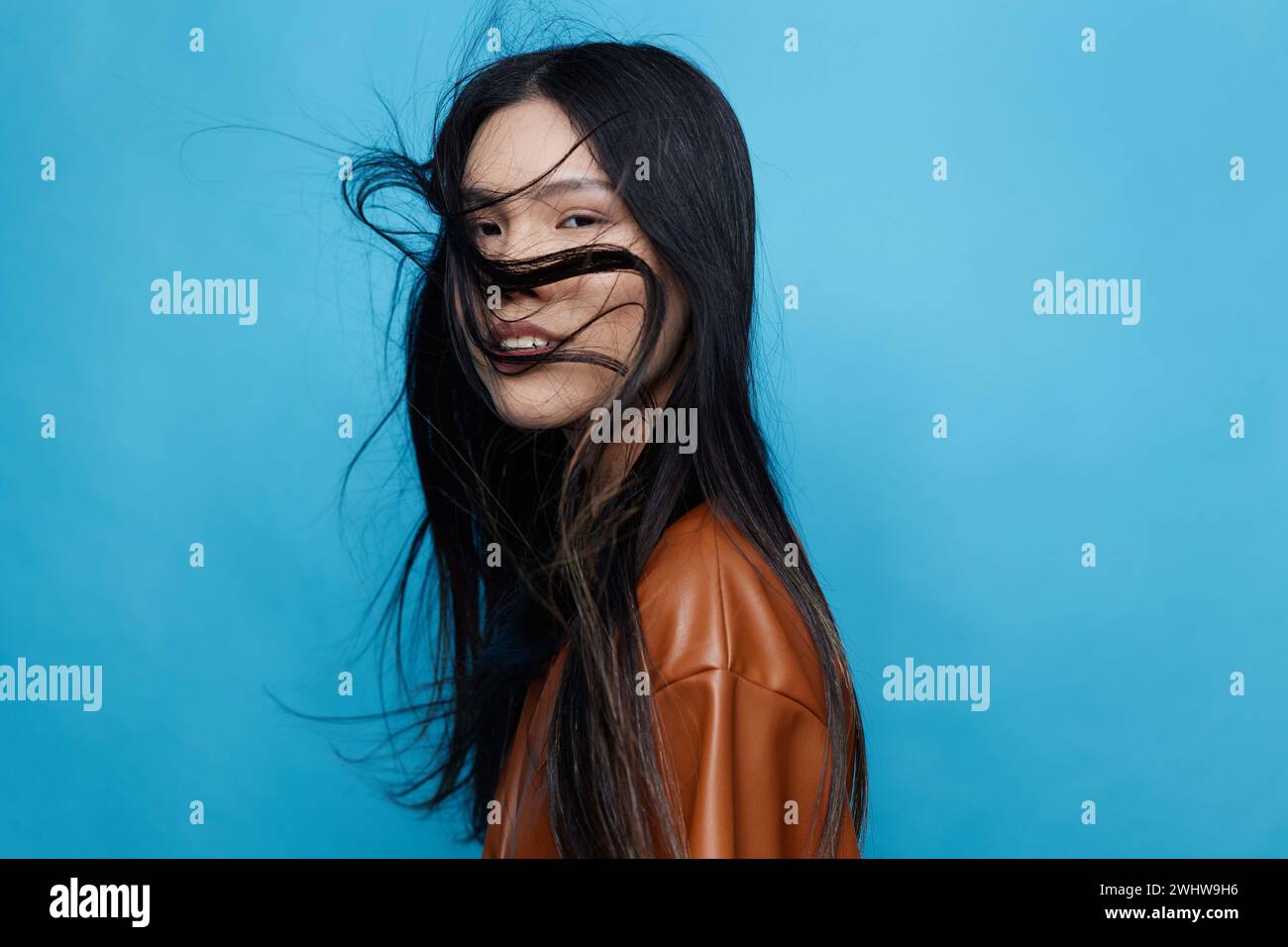 Happy woman blue asian background smile studio girl Stock Photo - Alamy