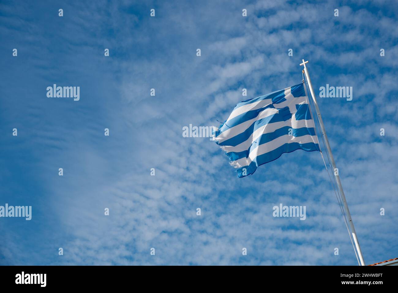 Greek blue and white flag waving against a blue dramatic cloudy sky ...