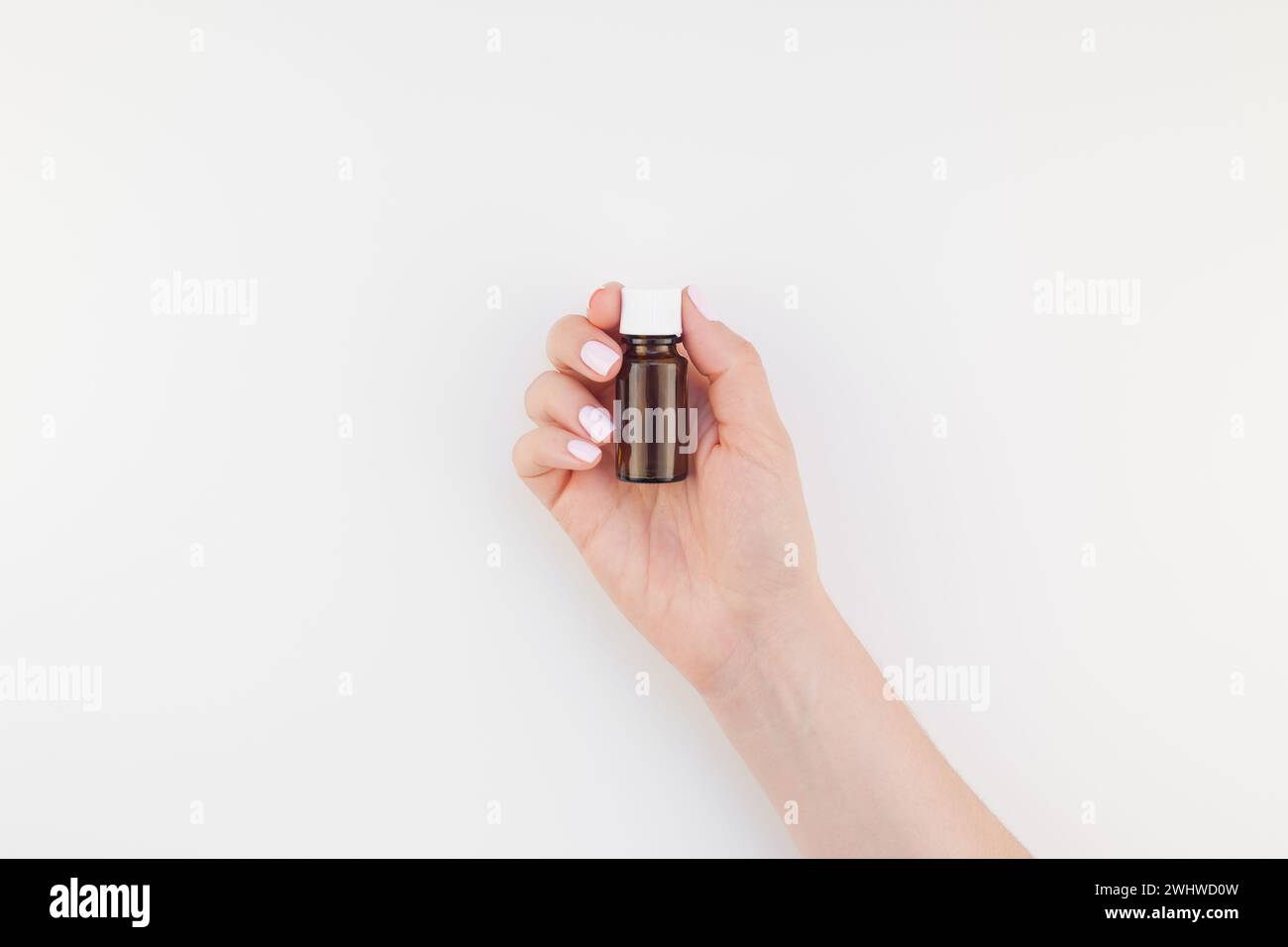 Woman hand with small glass bottle isolated Stock Photo - Alamy