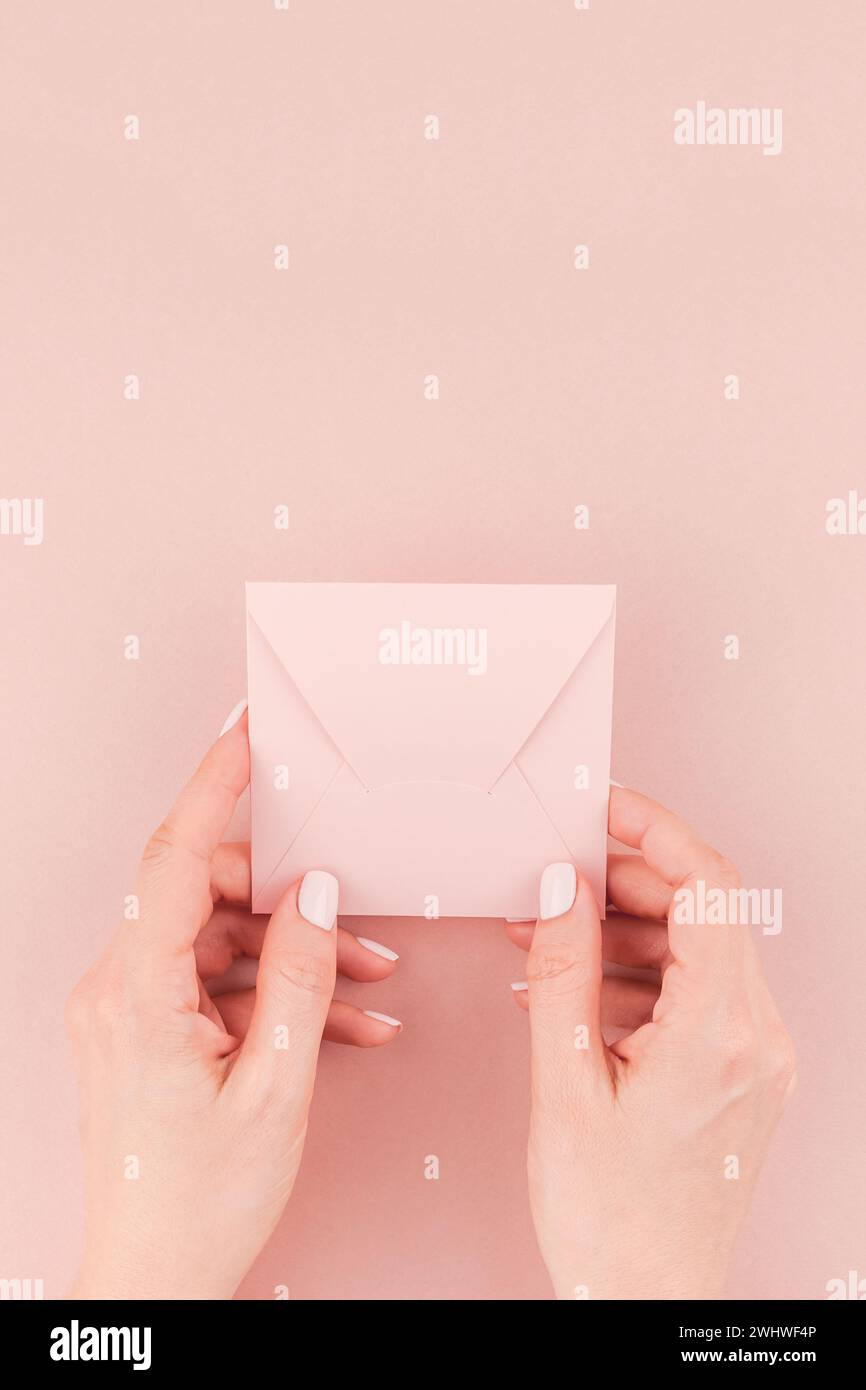Woman hand holding small pink love letter Stock Photo - Alamy
