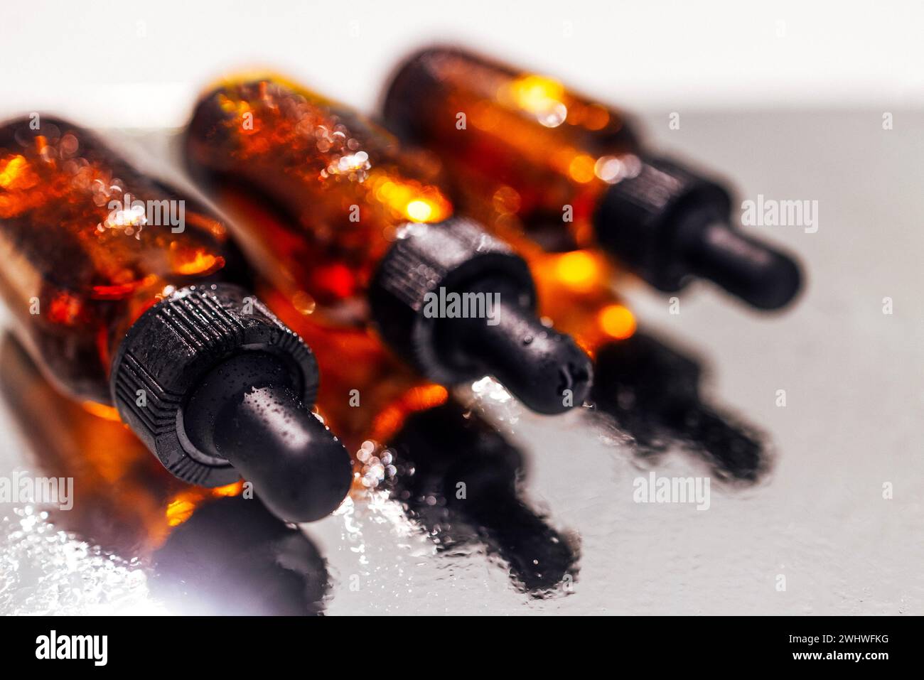 Group of bottles with drops on them and their reflection on a mirror ...