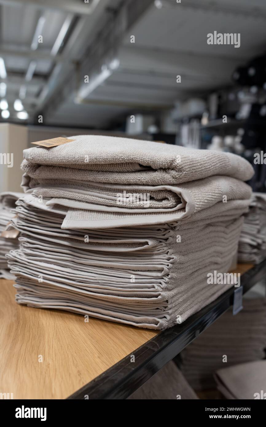 Home textiles, beautiful bath towels on the shelf. Pile of new towels ...