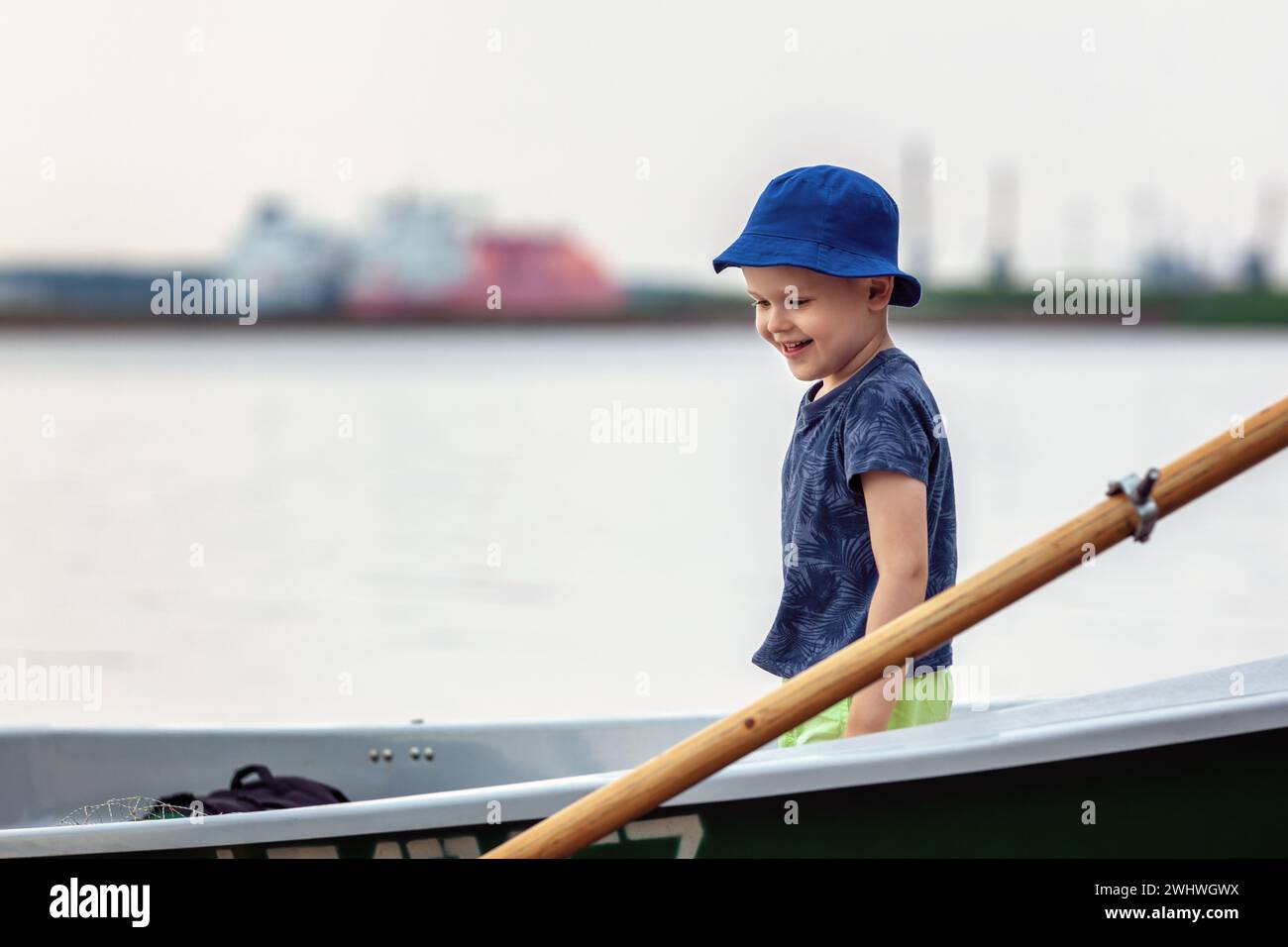 A cheerful boy in blue clothes poses in a fishing boat Stock Photo - Alamy