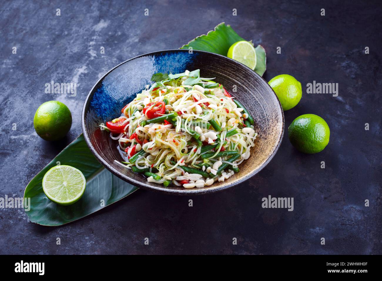 Traditional Thai green papaya som tam salad with green papaya slices ...