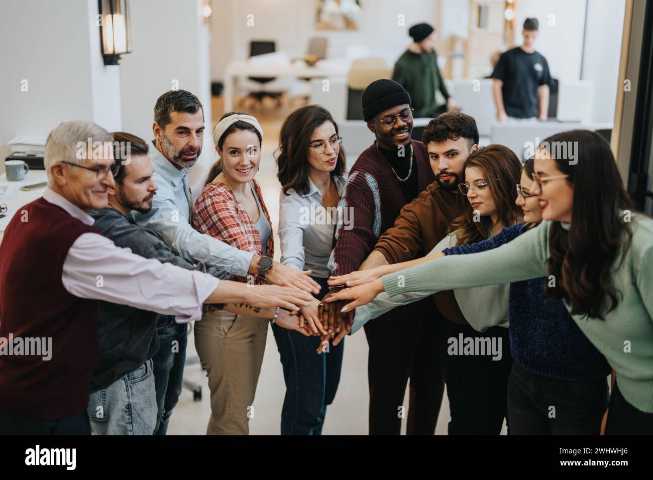 Diverse team joining hands together in unity at workplace Stock Photo ...