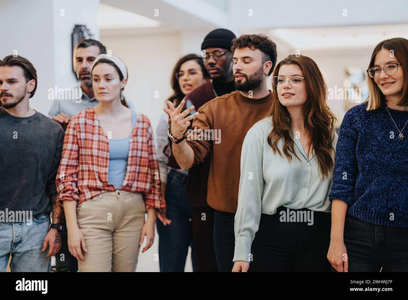 A group of men and women listening intently in a casual setting ...