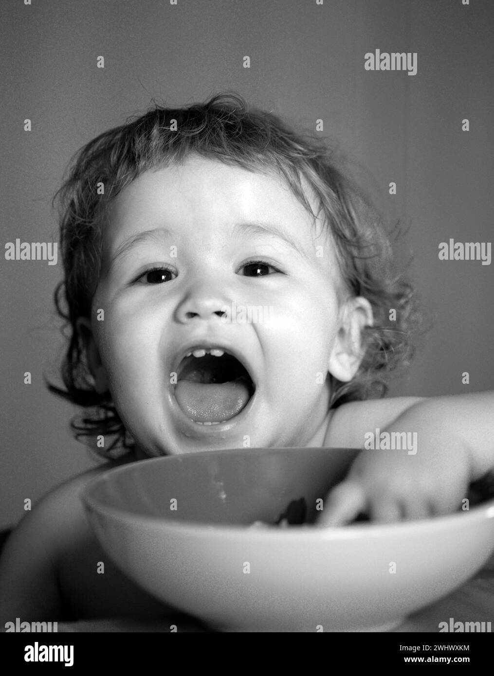 Portrait of cute Caucasian child kid with spoon. Hungry messy baby with ...