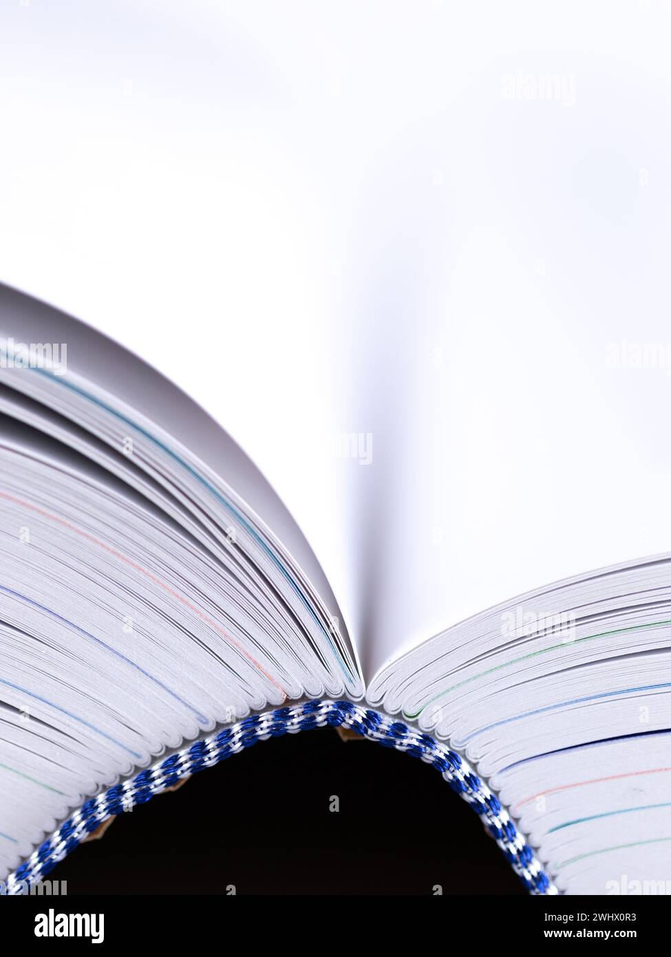 Close-up of an opened book with with a blue hard cover and blue and ...