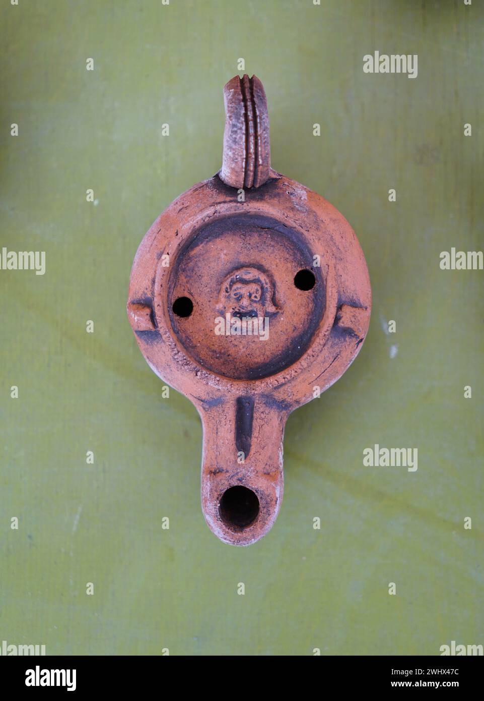 Roman oil lamp with mask motif Stock Photo - Alamy