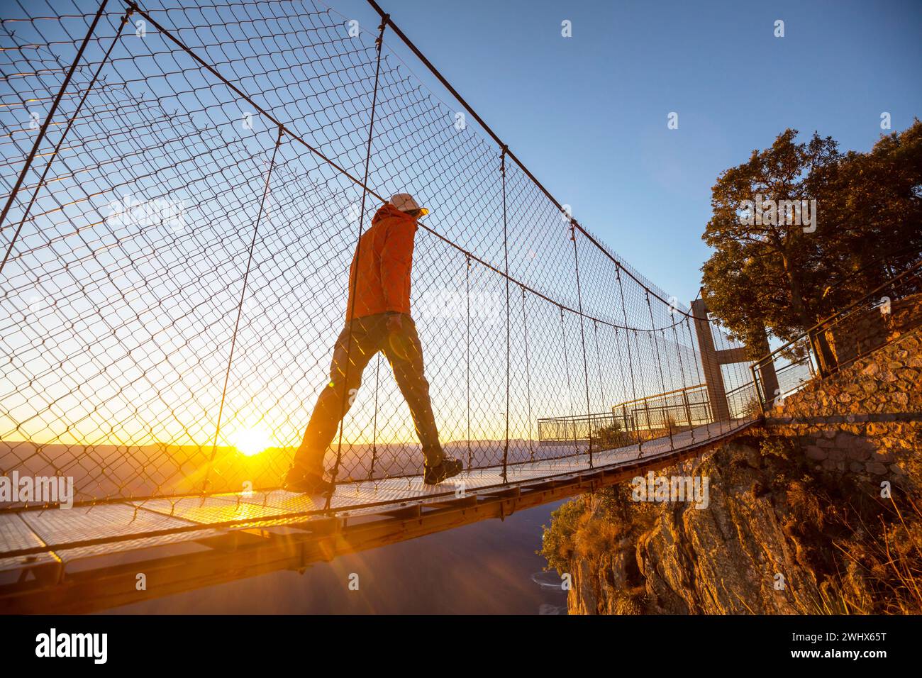 Man on suspension bridge Stock Photo - Alamy