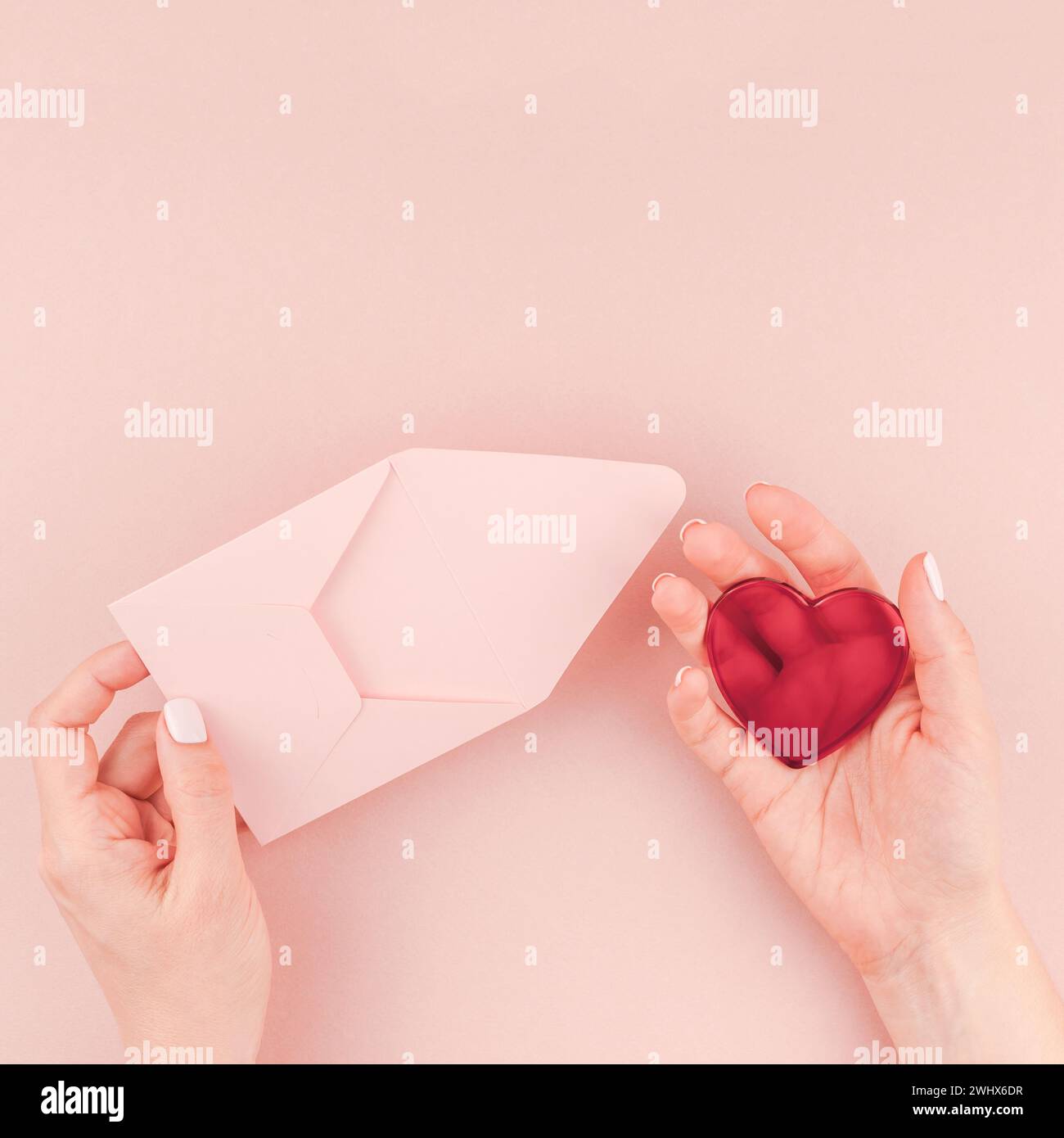 Woman hand holding small pink love letter Stock Photo - Alamy