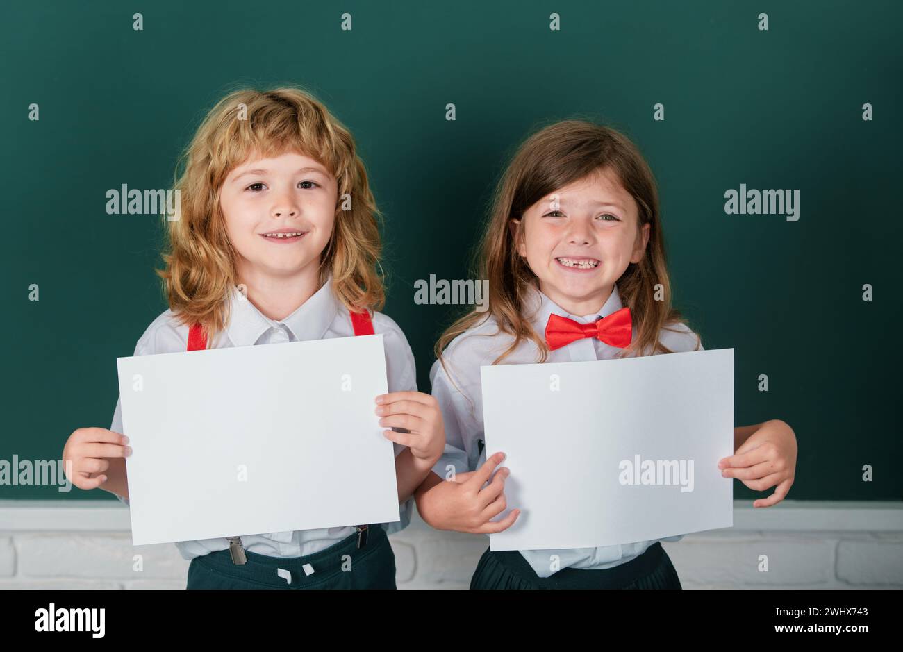 Cute little school kids friends studying together in classroom. Two ...