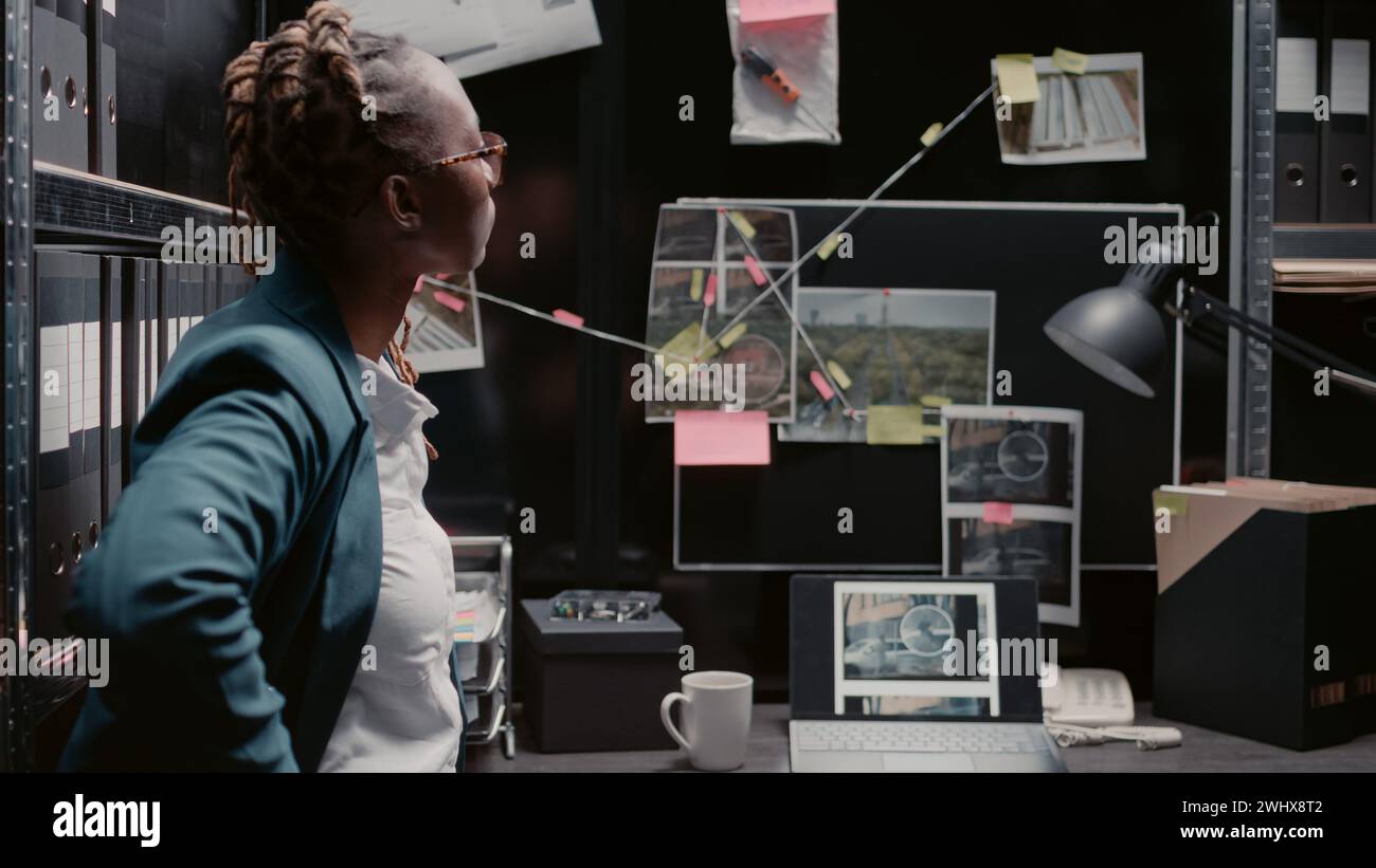 Professional officer reviewing surveillance photos on files to solve ...