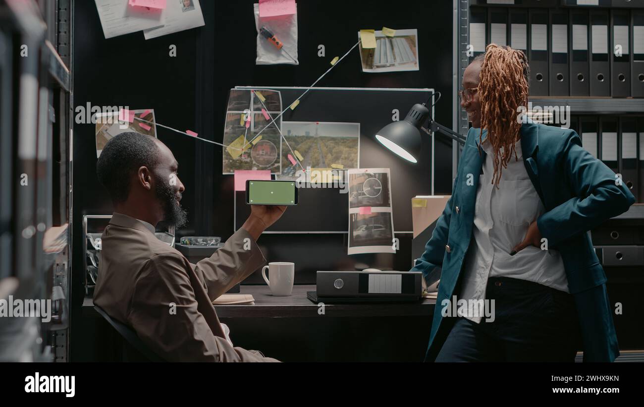 Law agents team analyzing phone with green screen, using isolated ...