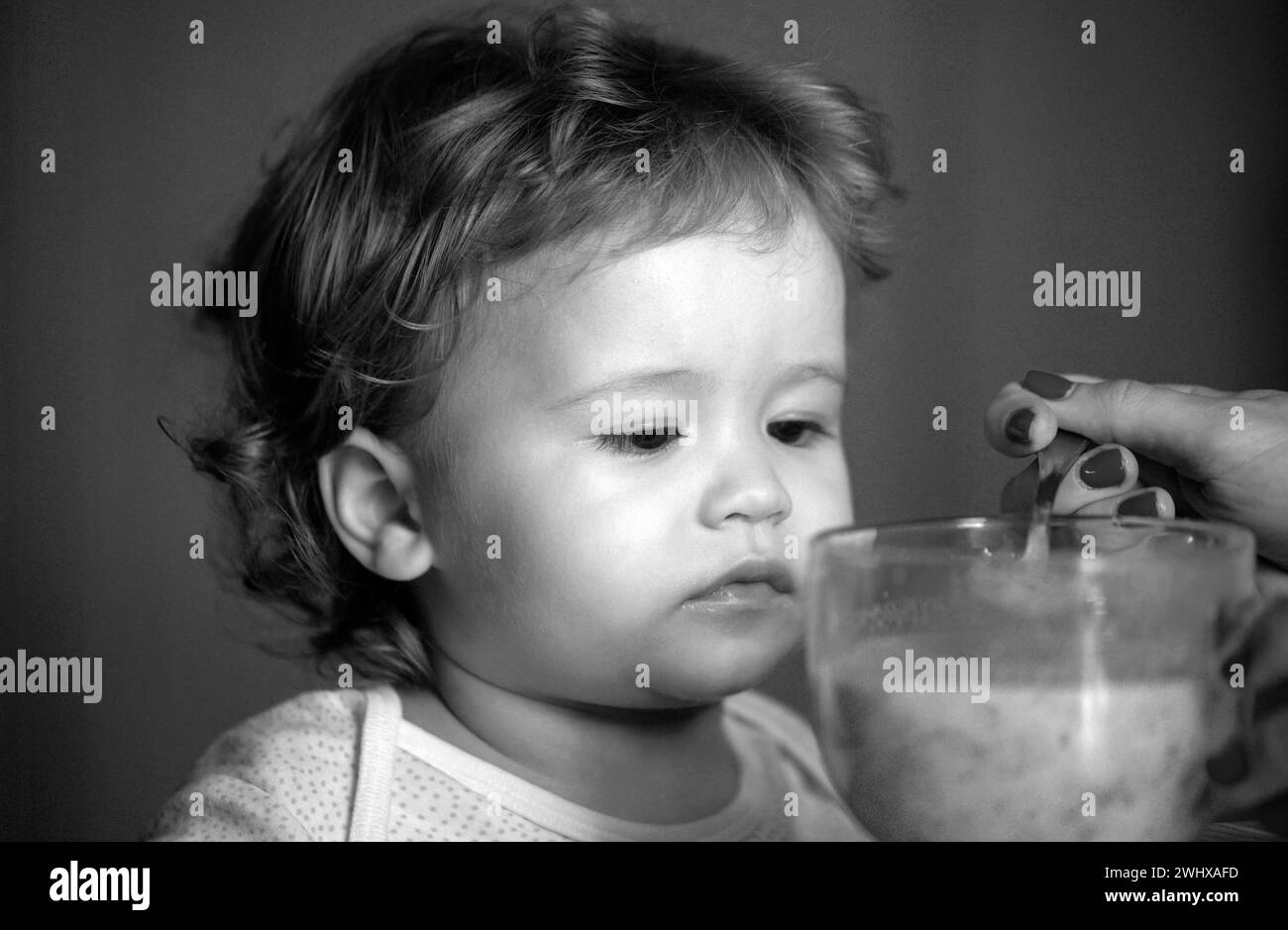 Mother giving healthy food to her adorable child at home. Feeding kids ...