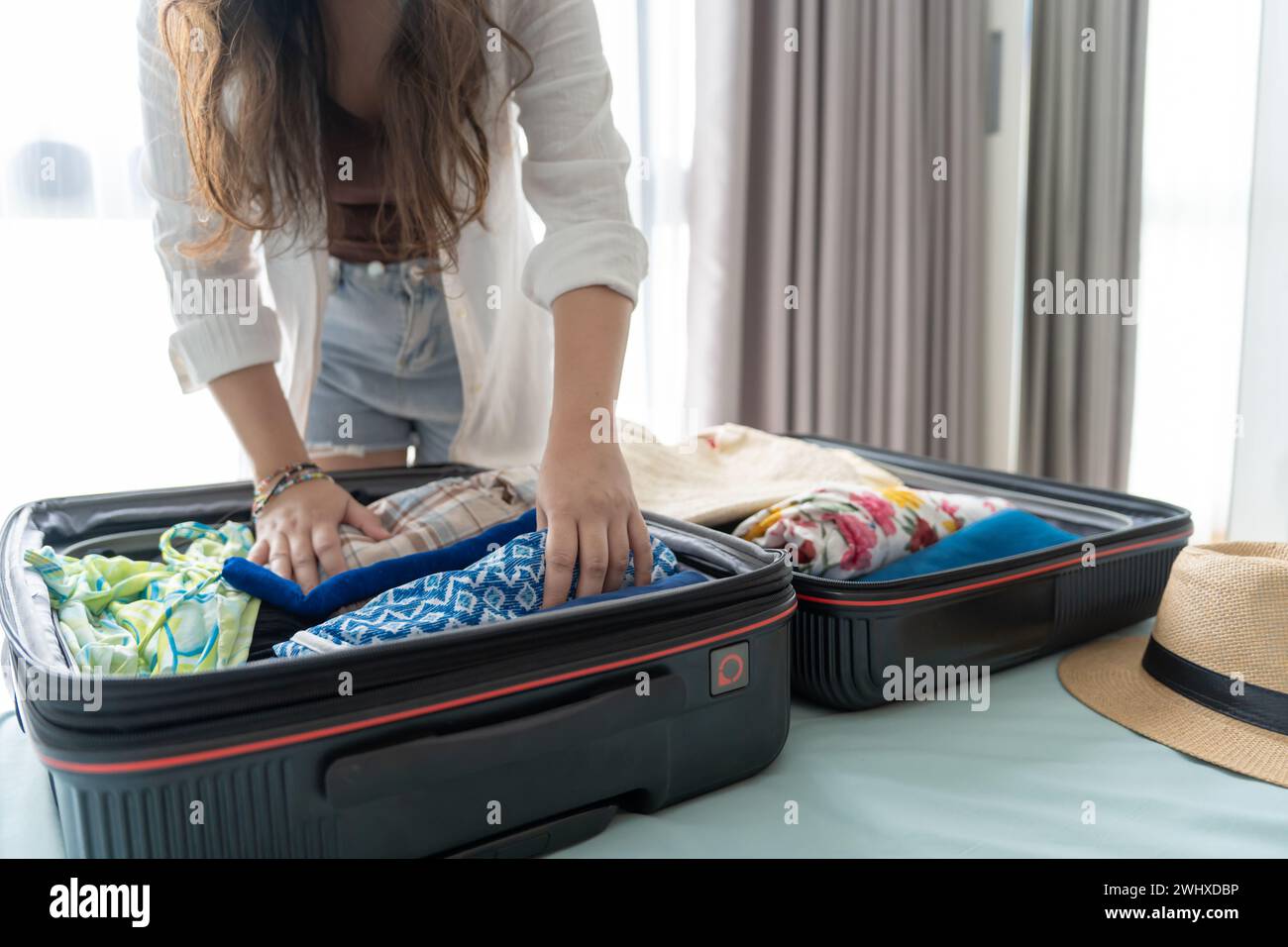 Woman packing suitcase on bed for a new journey packing list for travel ...