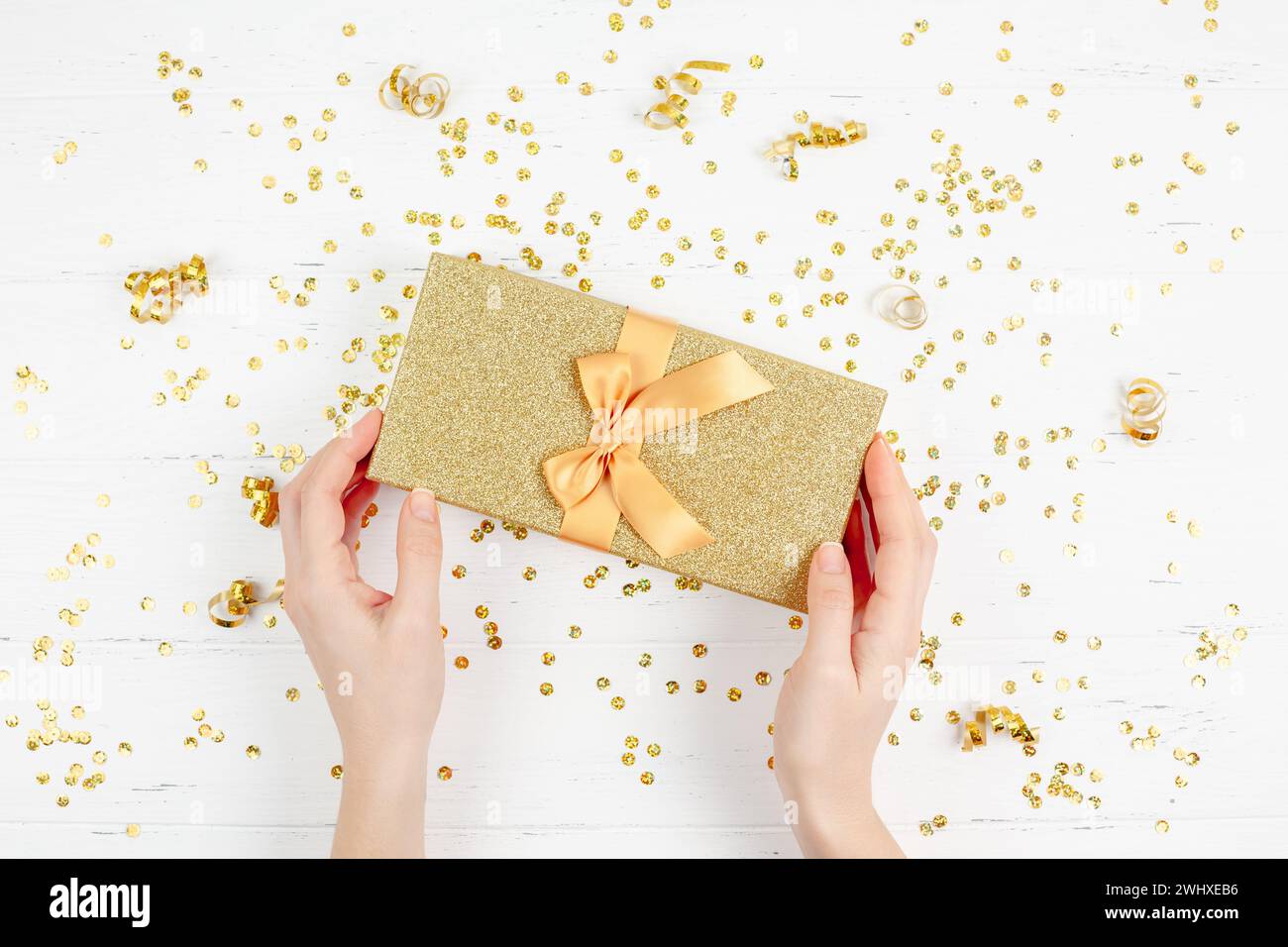 Golden gift box with confetti Stock Photo - Alamy