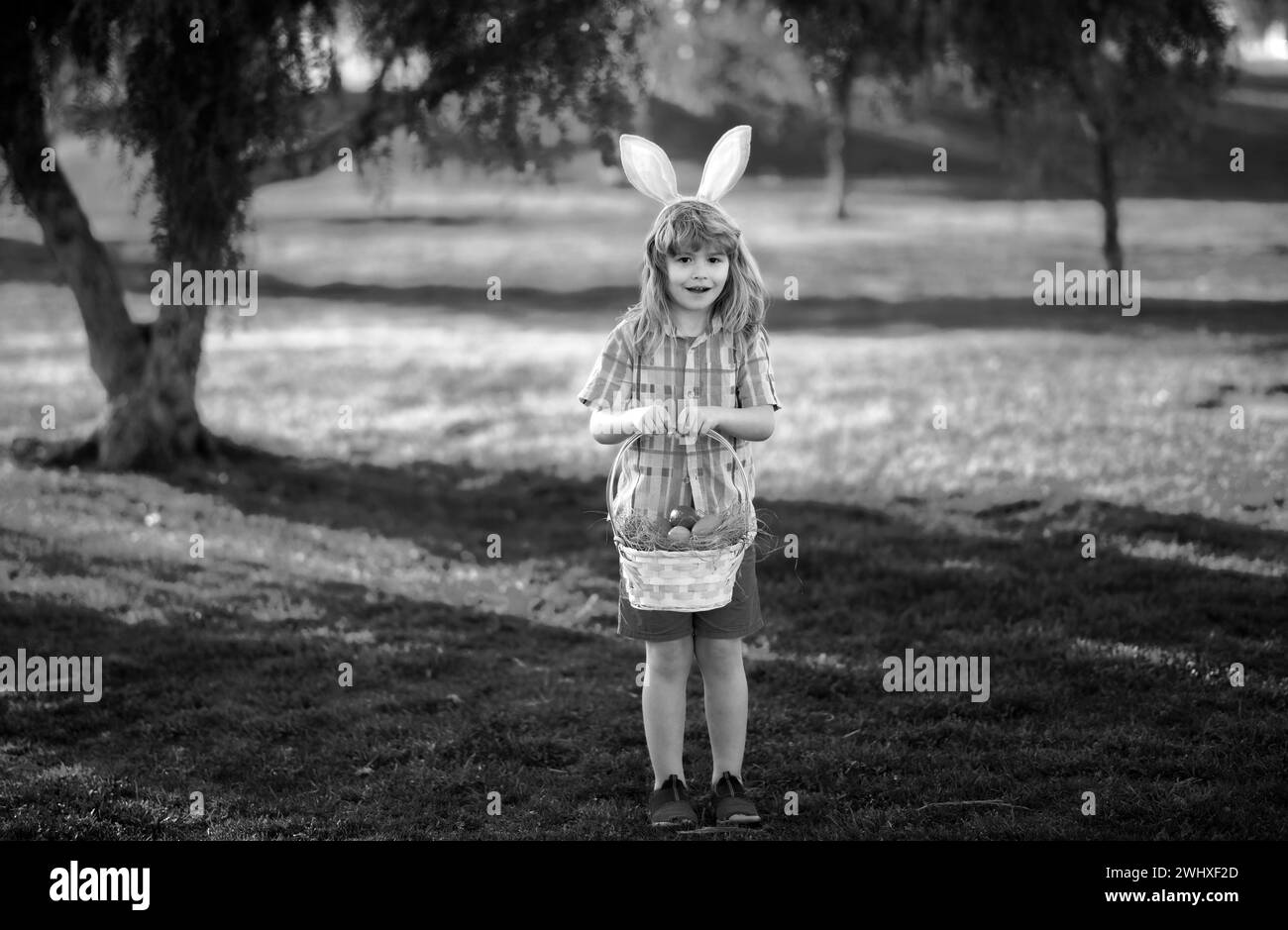 Child boy hunting easter eggs, laying on grass. Kid in rabbit bunny ...