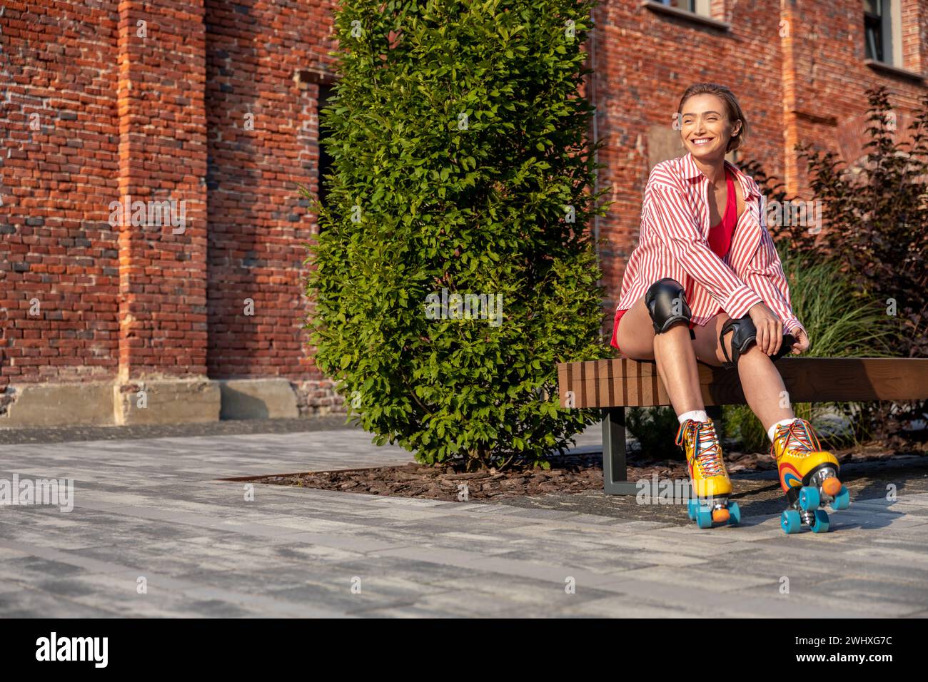 Woman having a rest on the bench after skating Stock Photo - Alamy