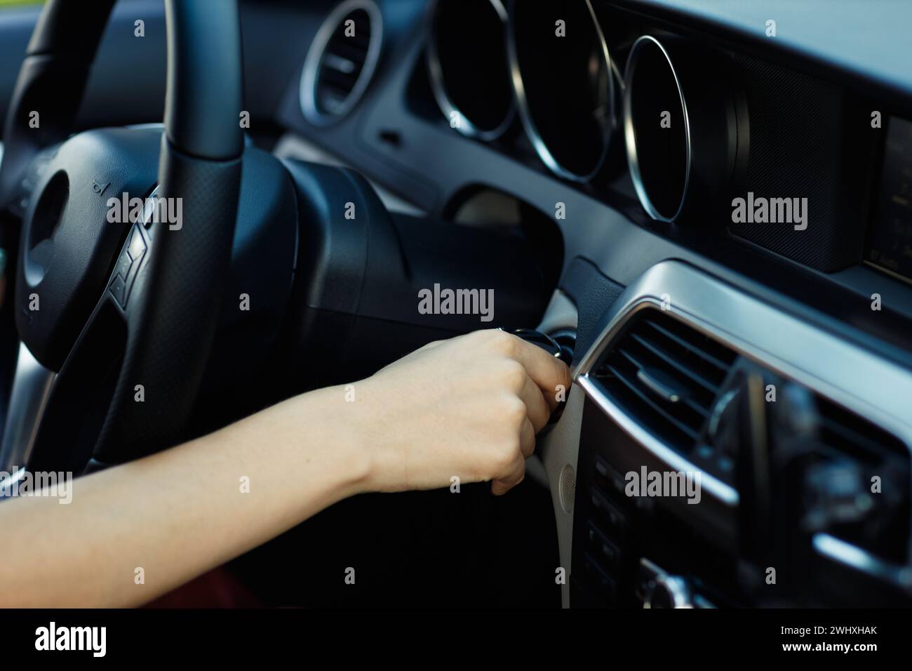 Young woman driver hands close up starts the engine with a key car ...