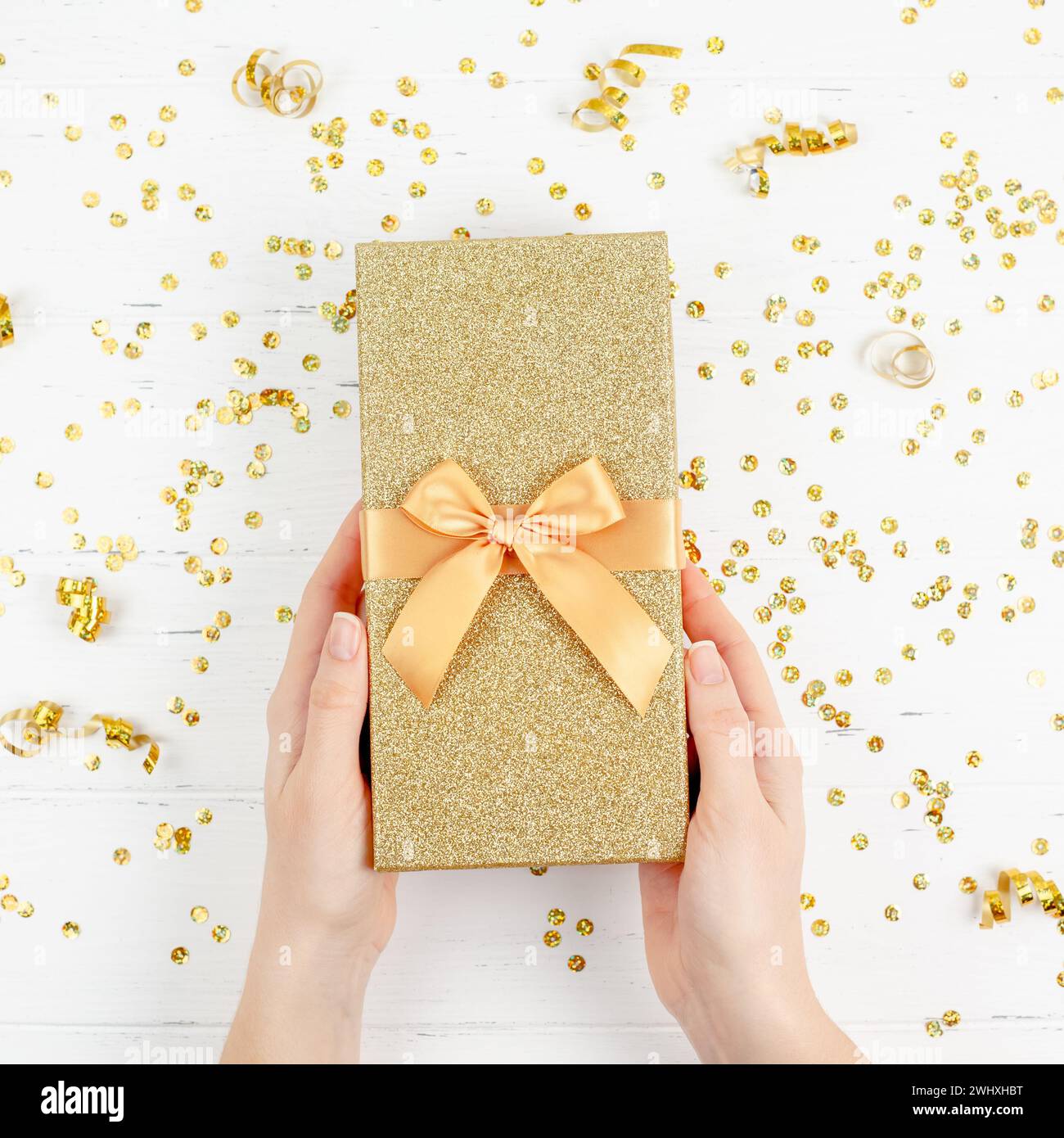 Golden gift box with confetti Stock Photo - Alamy