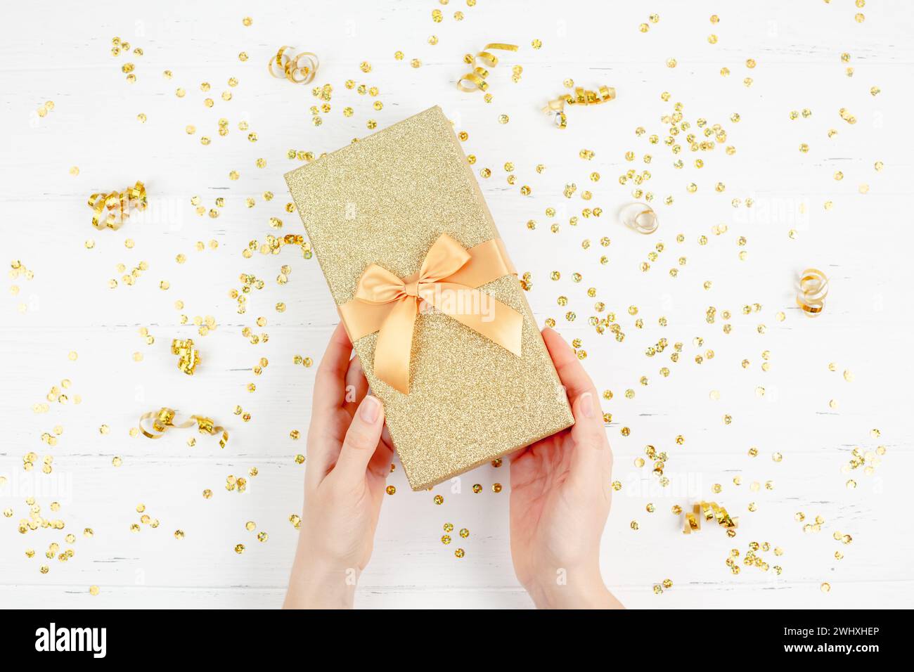 Golden gift box with confetti Stock Photo - Alamy