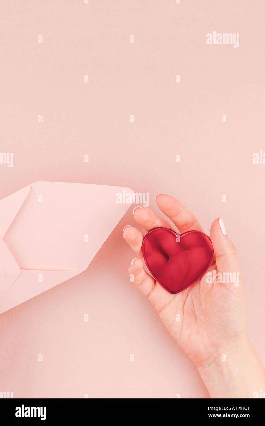 Woman hand holding small pink love letter Stock Photo - Alamy