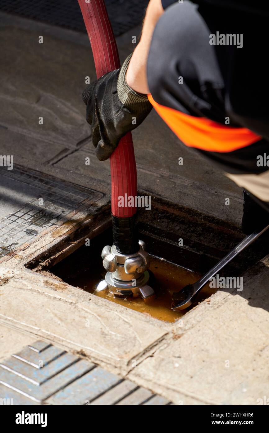 Firefighter connecting hose to a fire hydrant on the street in order to ...