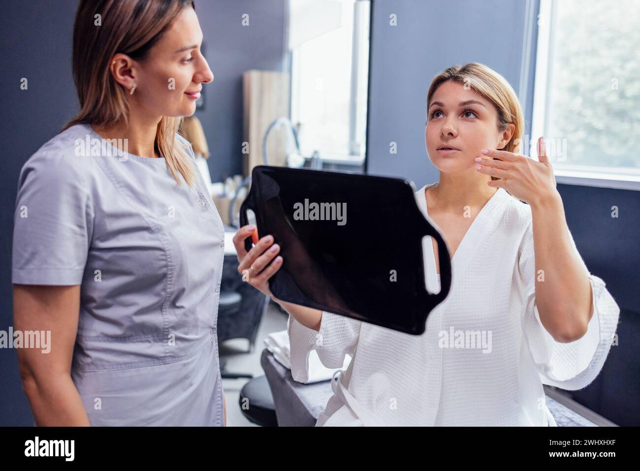 Doctor checking woman face skin in cosmetology clinic before plastic ...