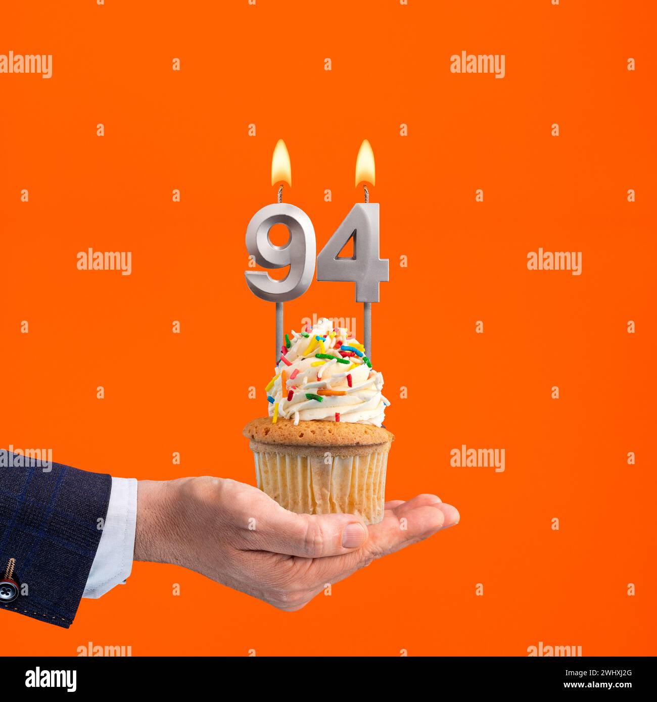 The hand that delivers cupcake with the number 94 candle - Birthday on ...