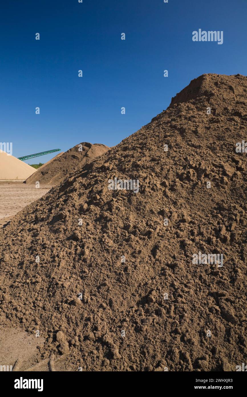 Mounds of fine brown and tan coloured sand and stacking conveyor in ...