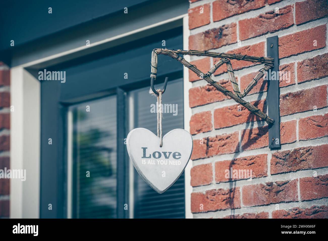 Decorative heart hanging on the brick wall Stock Photo - Alamy