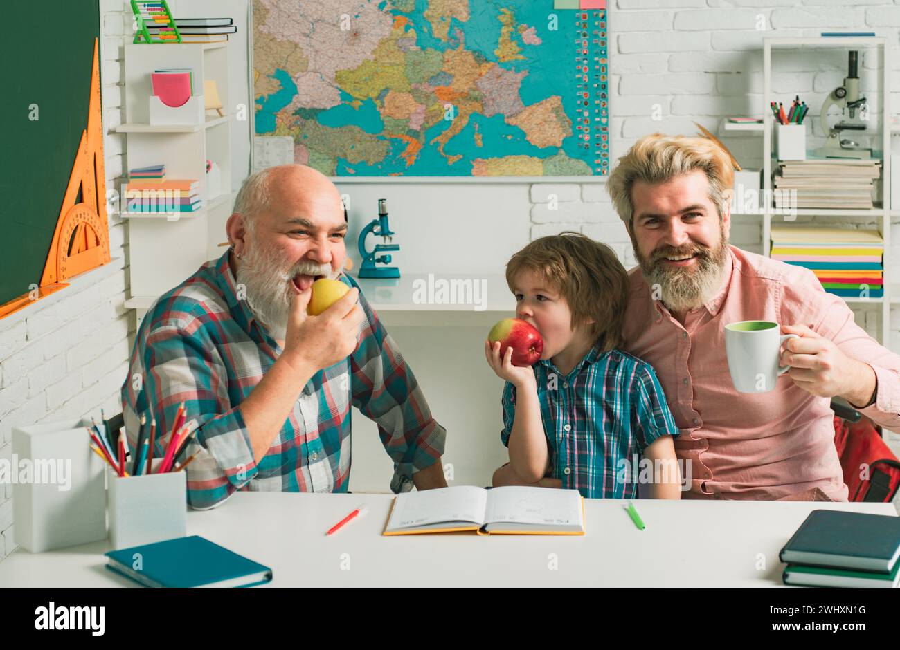 Fathers day. Happy smiling grandson boy with dad and granddad learning ...