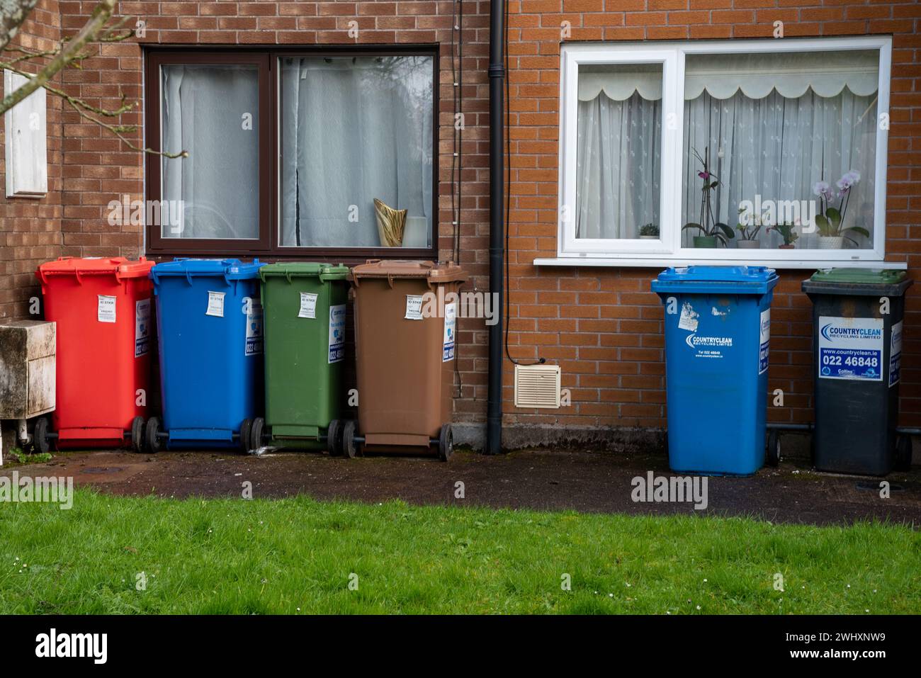 Recycling bins outside residential houses. Reuse saving the environment ...