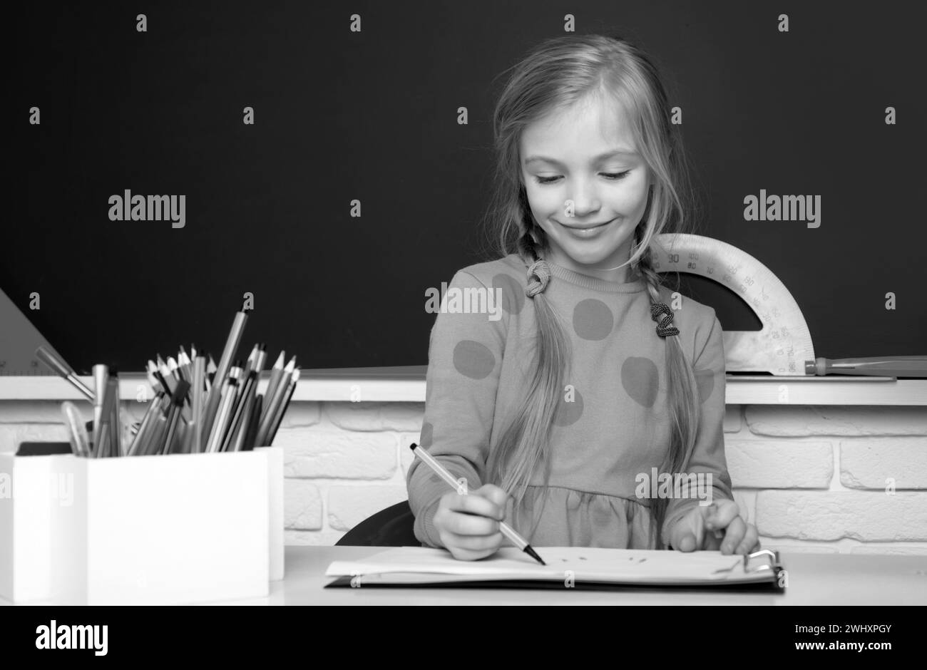 School concept. Kid writing on textbook. Little student doing homework ...