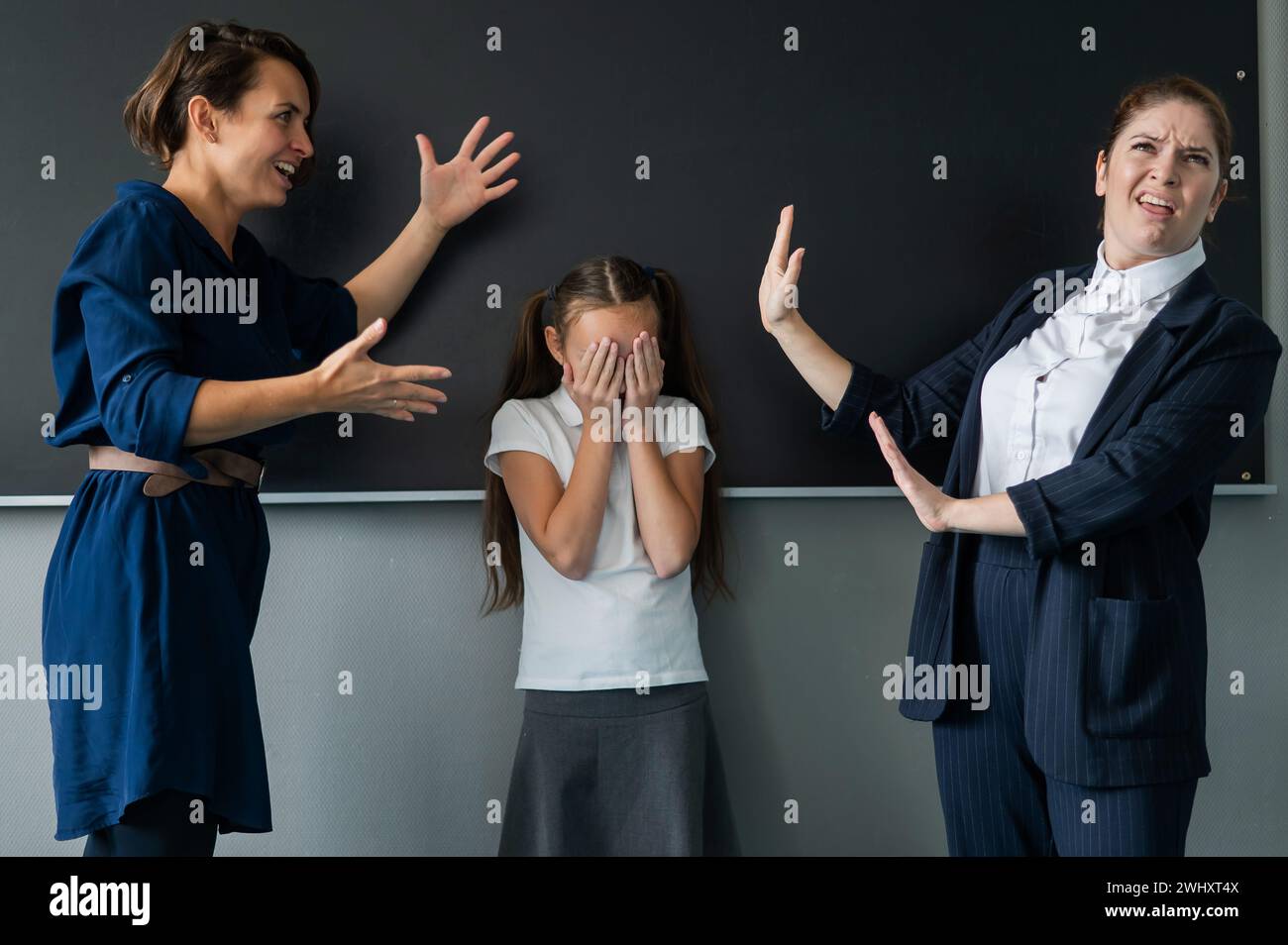 Schoolgirl and her mother yell at the teacher standing at the ...