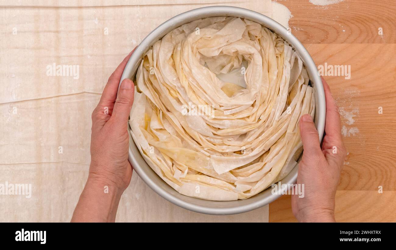 Phyllo dough pastry filled with cream cheese recipe. Woman hands roll ...