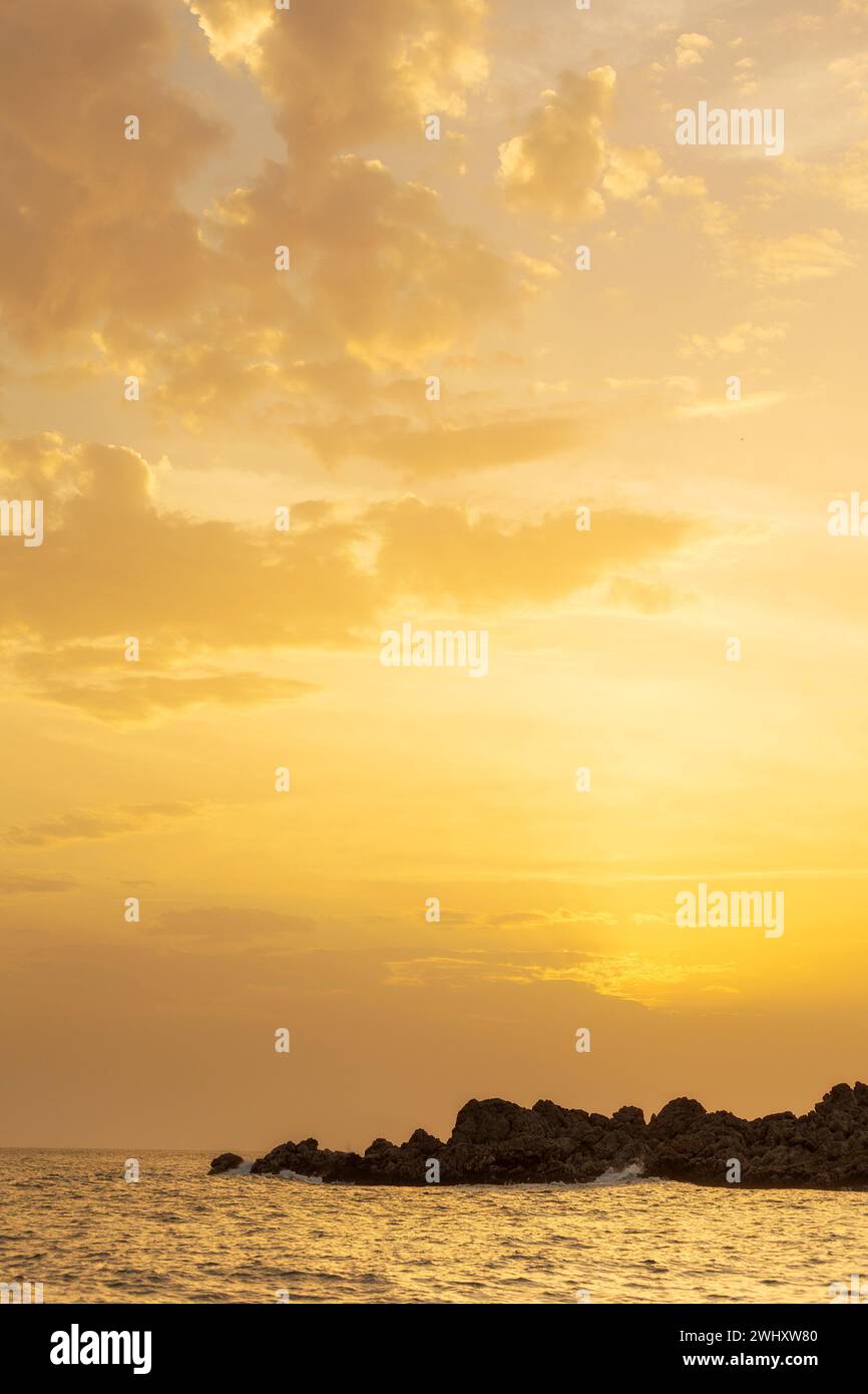 Beach golden sunset sky, stone rocks background Stock Photo - Alamy